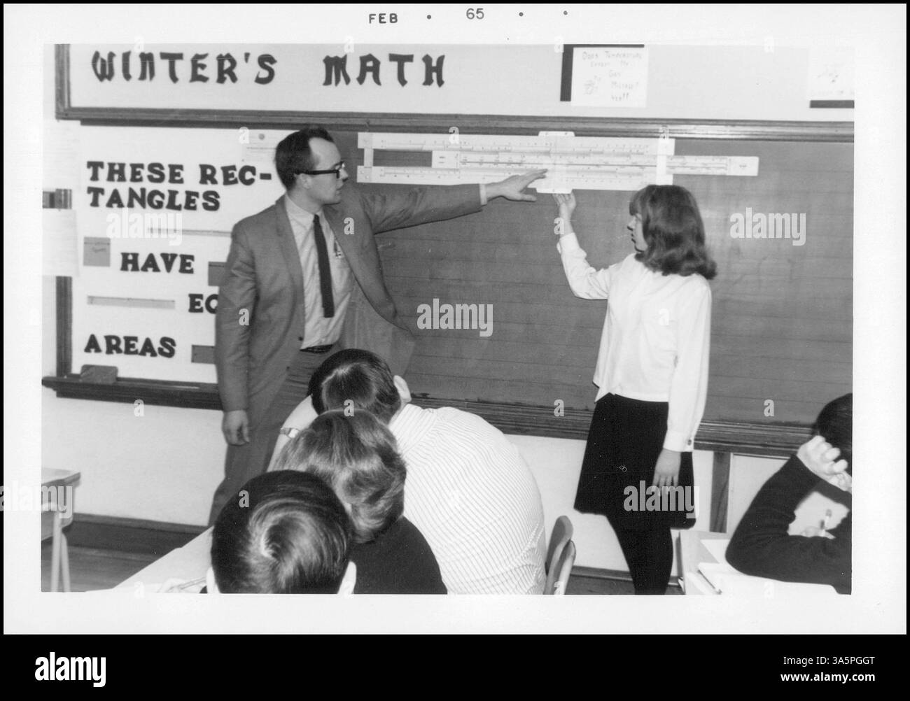 This 1965 photograph shows a classroom with a slide rule, an important ...