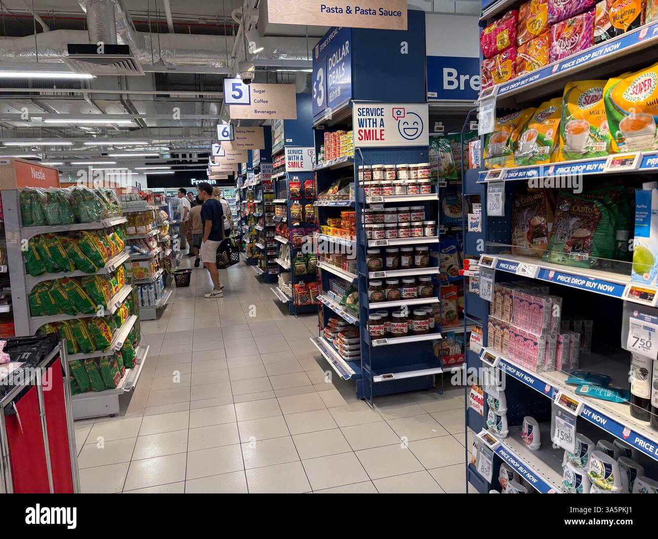 Interior shot of a supermarket aisle with shoppers in Singapore ...