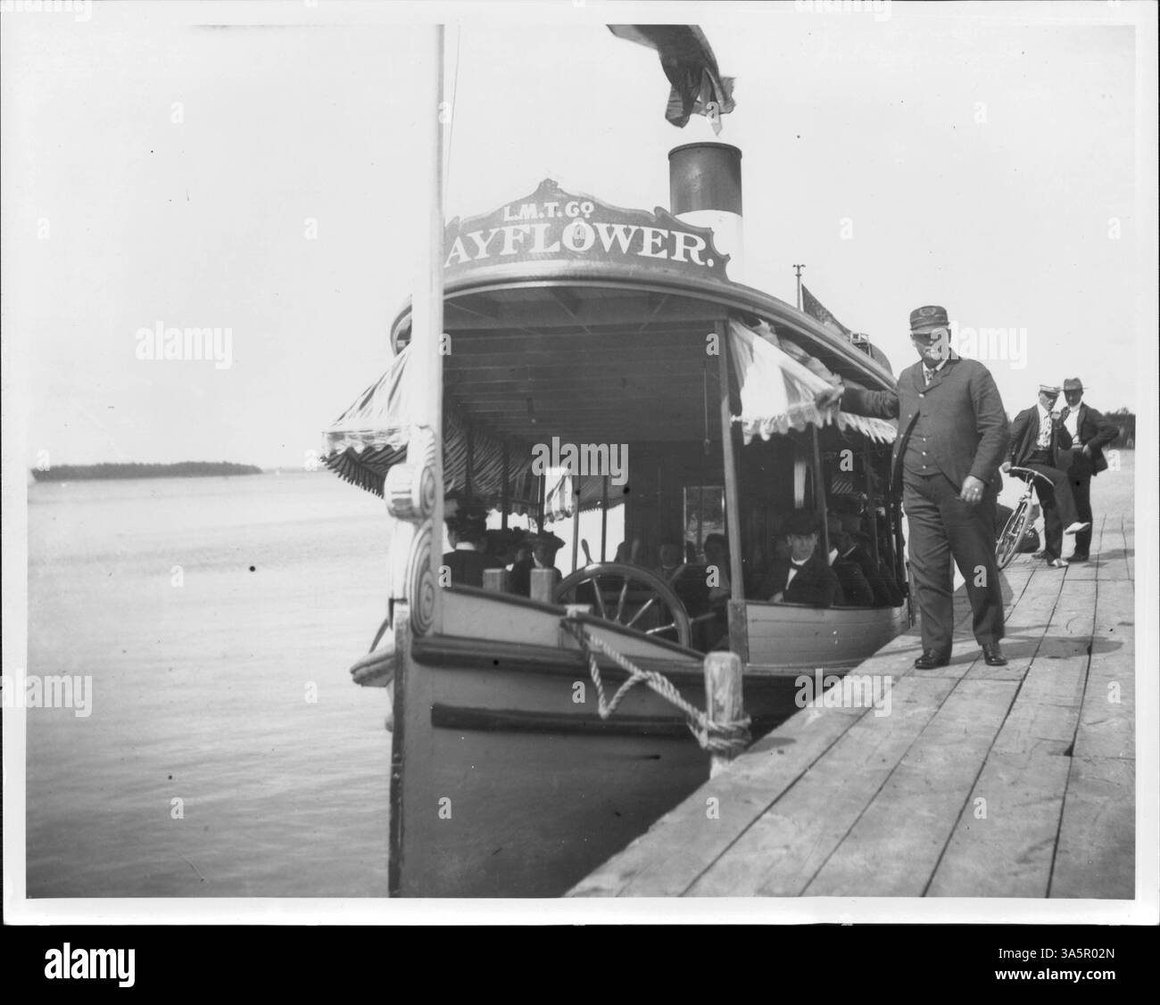 The 'Mayflower' boat is docked on Lake Minnetonka, with a uniformed man ...