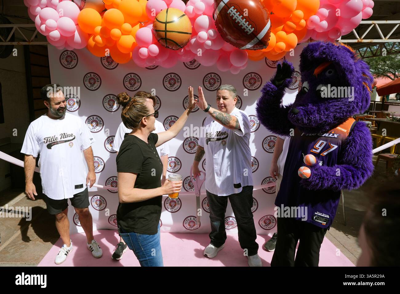 Audrey Corley, center, co-founder of the Title 9 Sports Grill, gets a ...
