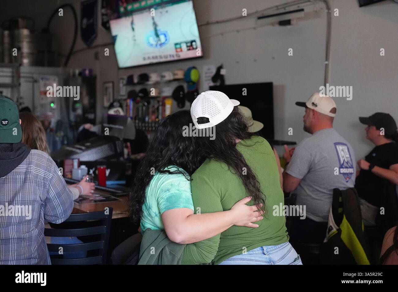 A couple hug as they watch a women's basketball game in The 99ers, the ...
