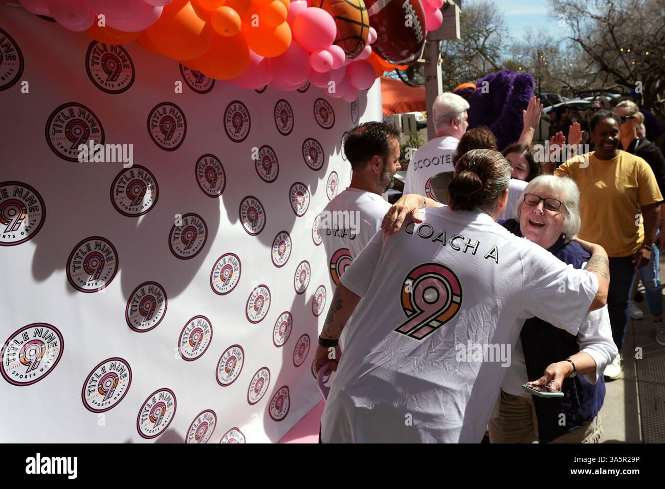 Audrey Corley, left, co-founder of the Title 9 Sports Grill, gets a hug ...