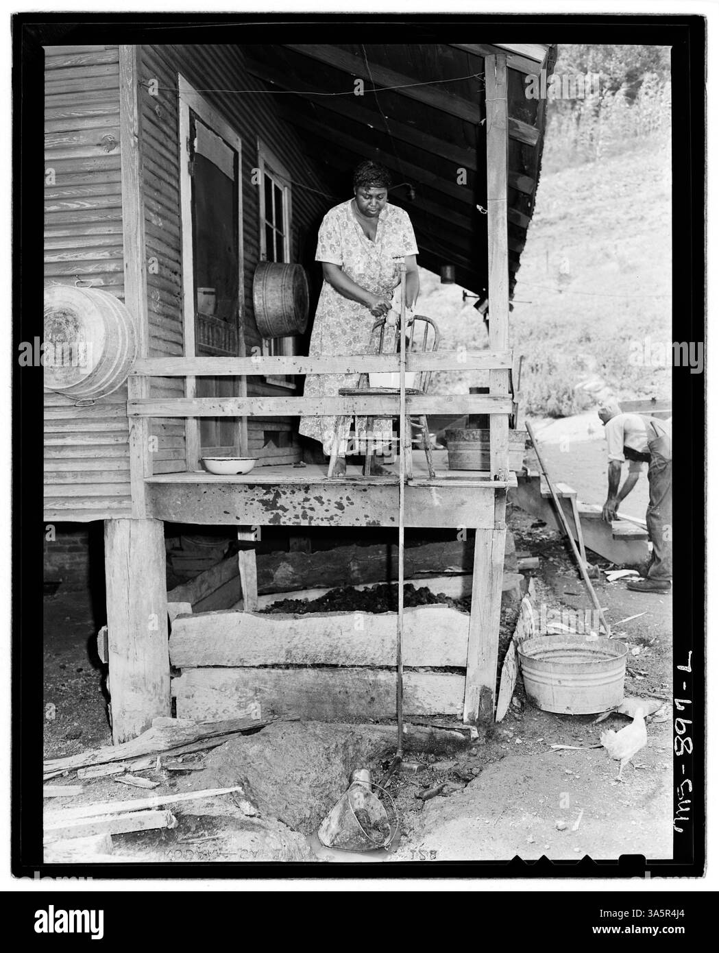 Mrs. Butler Phillips, wife of a miner, is seen dressing a chicken on ...