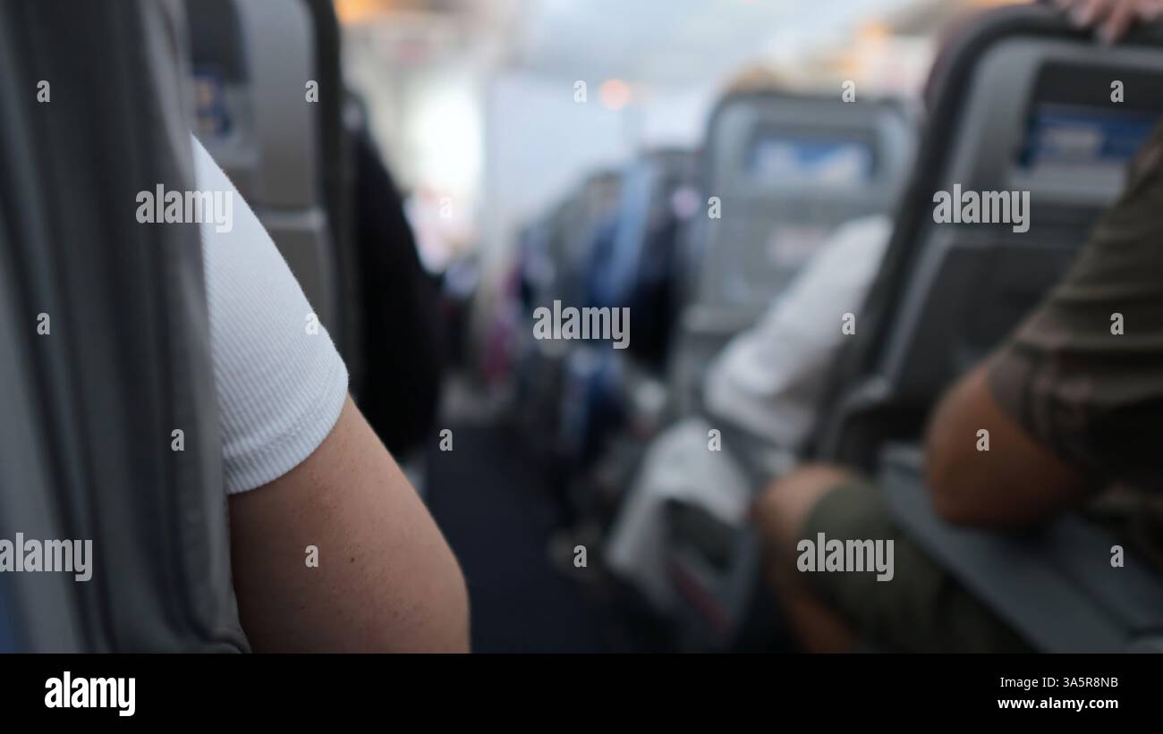 Passenger arm resting on airplane seat during flight Stock Photo - Alamy