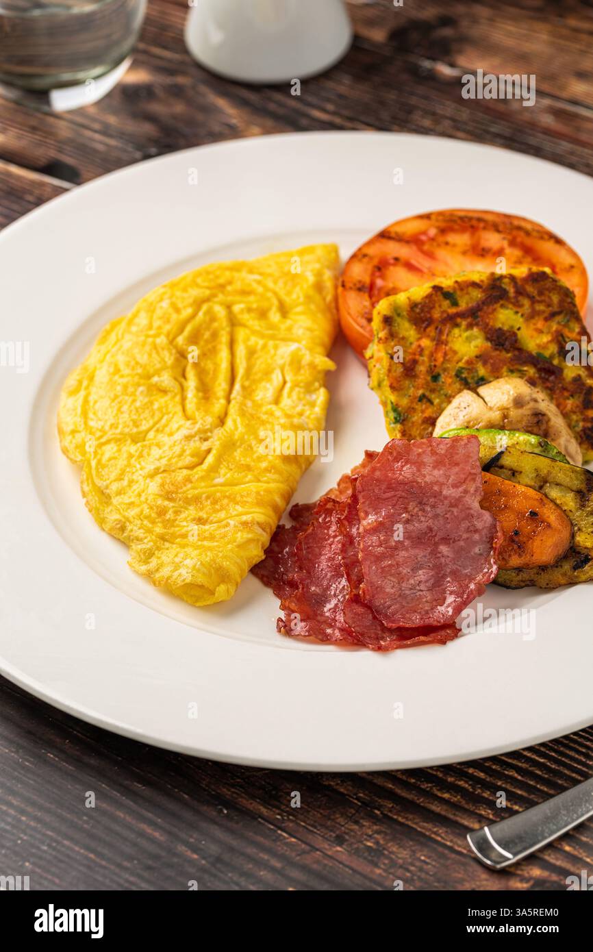 Rustic breakfast plate with fried eggs, grilled vegetables, and turkey ...