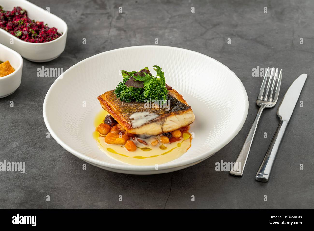 Crispy-skinned pan-seared fish fillet with chickpeas, creamy sauce, and ...