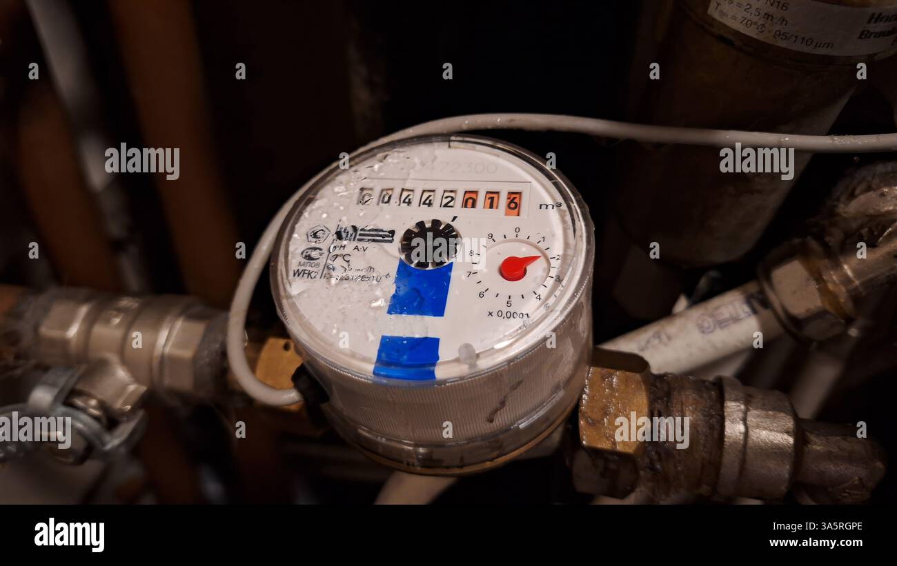 The close -up of a mechanical meter of cold water with pipe joints ...