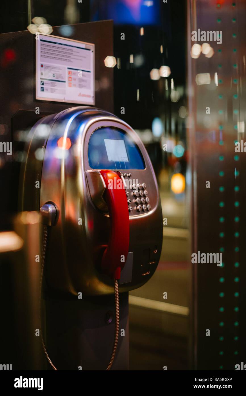 Old pay phone inside public phone booth at night in a city in Europe ...