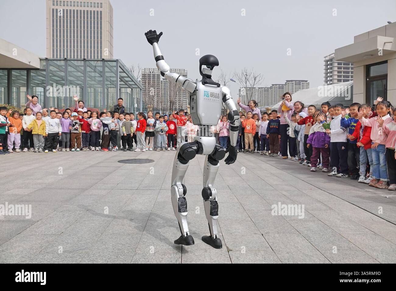 YANTAI, CHINA - MARCH 24, 2025 - A UNITREE G1 humanoid robot waves to ...