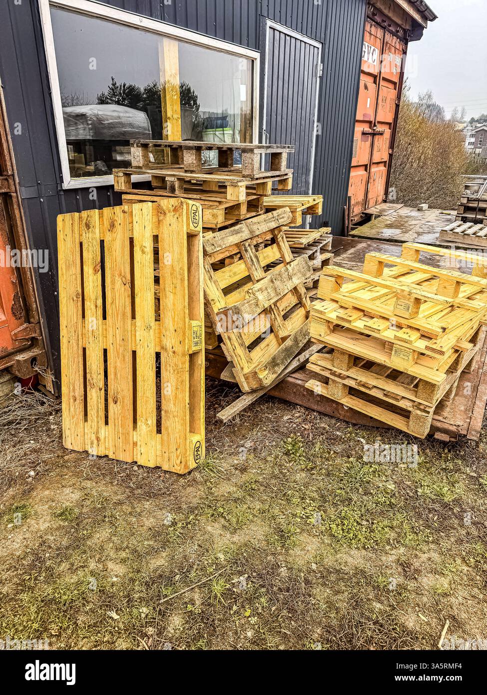 A storage area features stacks of wooden pallets and construction ...