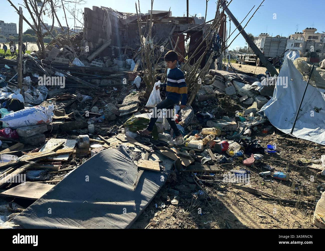 Palestinians inspect the destruction after Israeli airstrike on tents ...