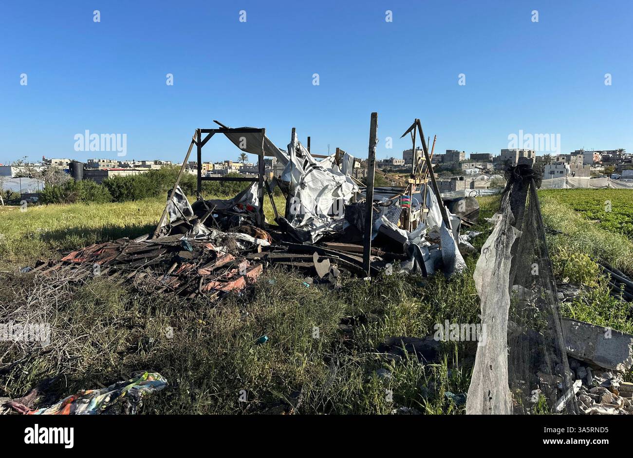 Palestinians inspect the destruction after Israeli airstrike on tents ...