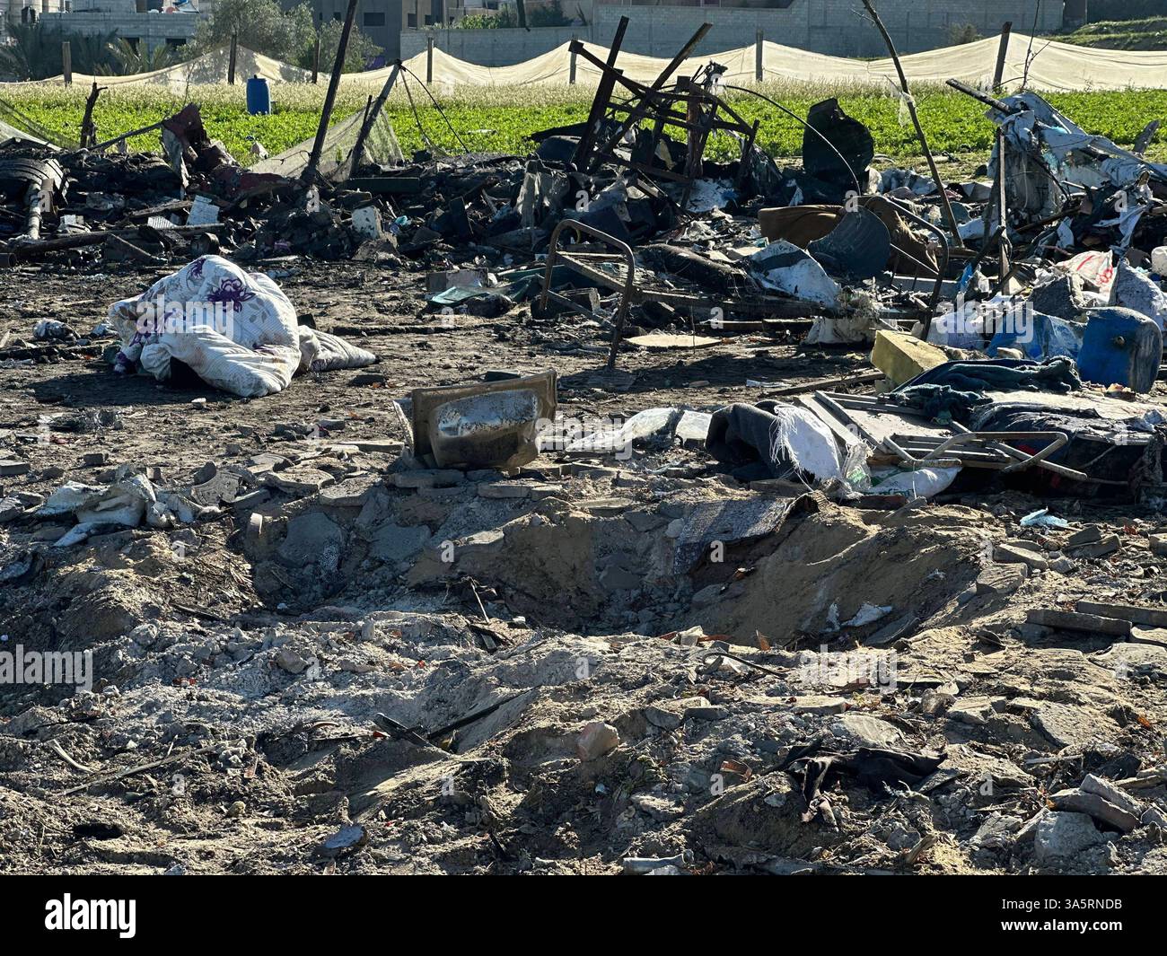 Palestinians inspect the destruction after Israeli airstrike on tents ...