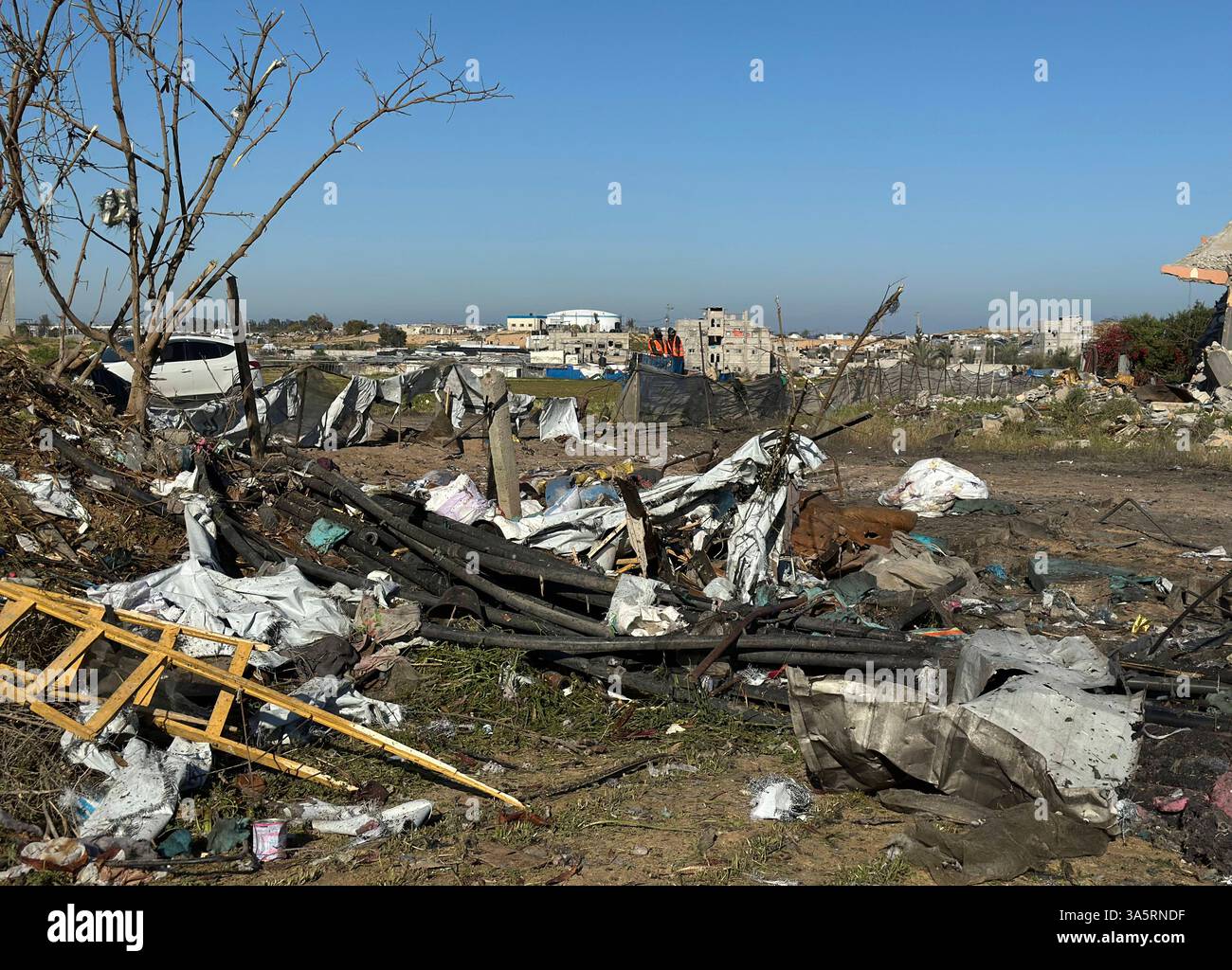 Palestinians inspect the destruction after Israeli airstrike on tents ...