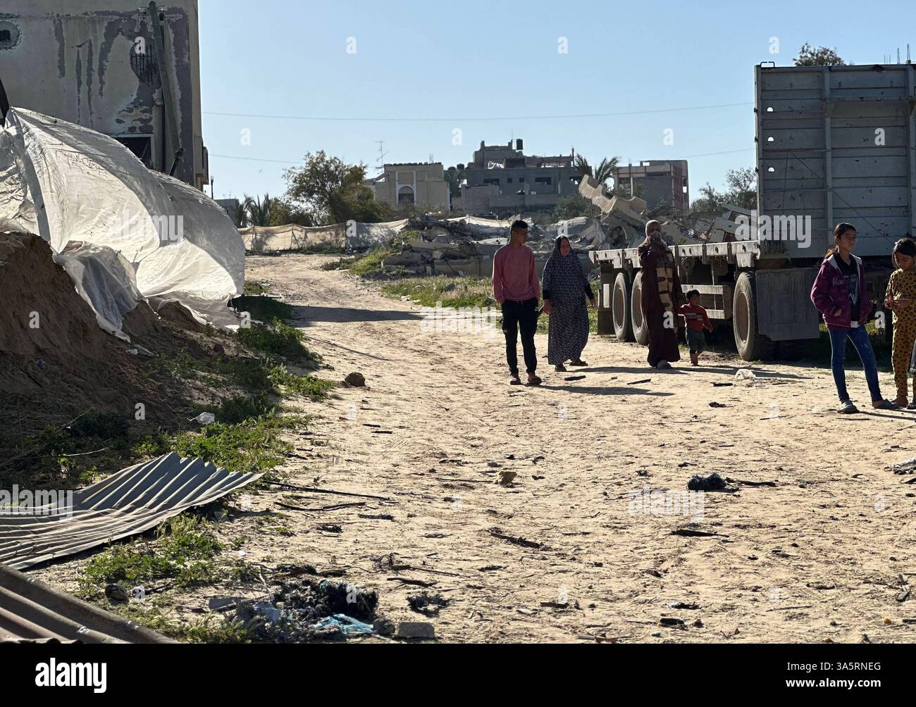 Palestinians inspect the destruction after Israeli airstrike on tents ...