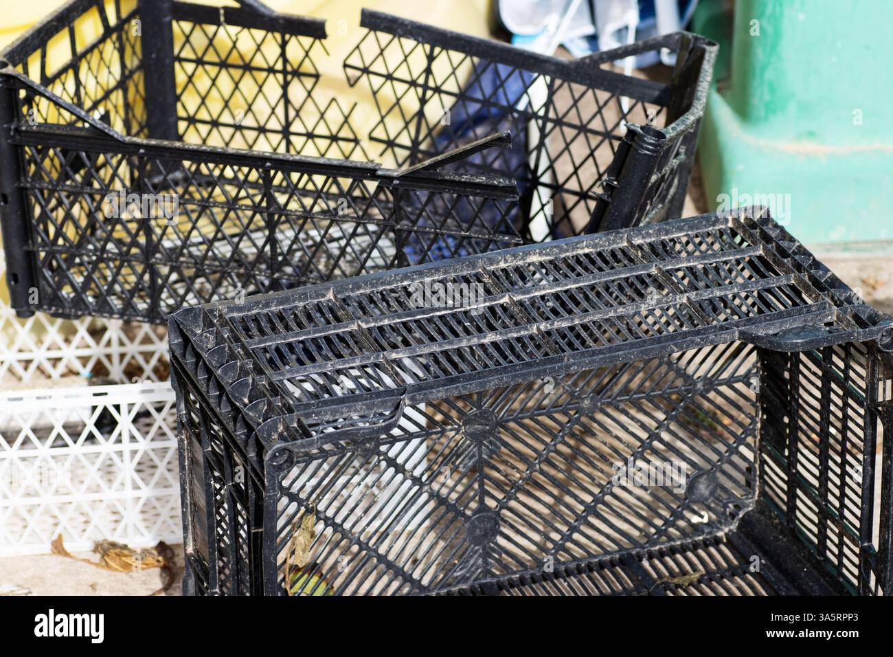 pile of broken plastic crates discarded on a rubbish bin for garbage ...