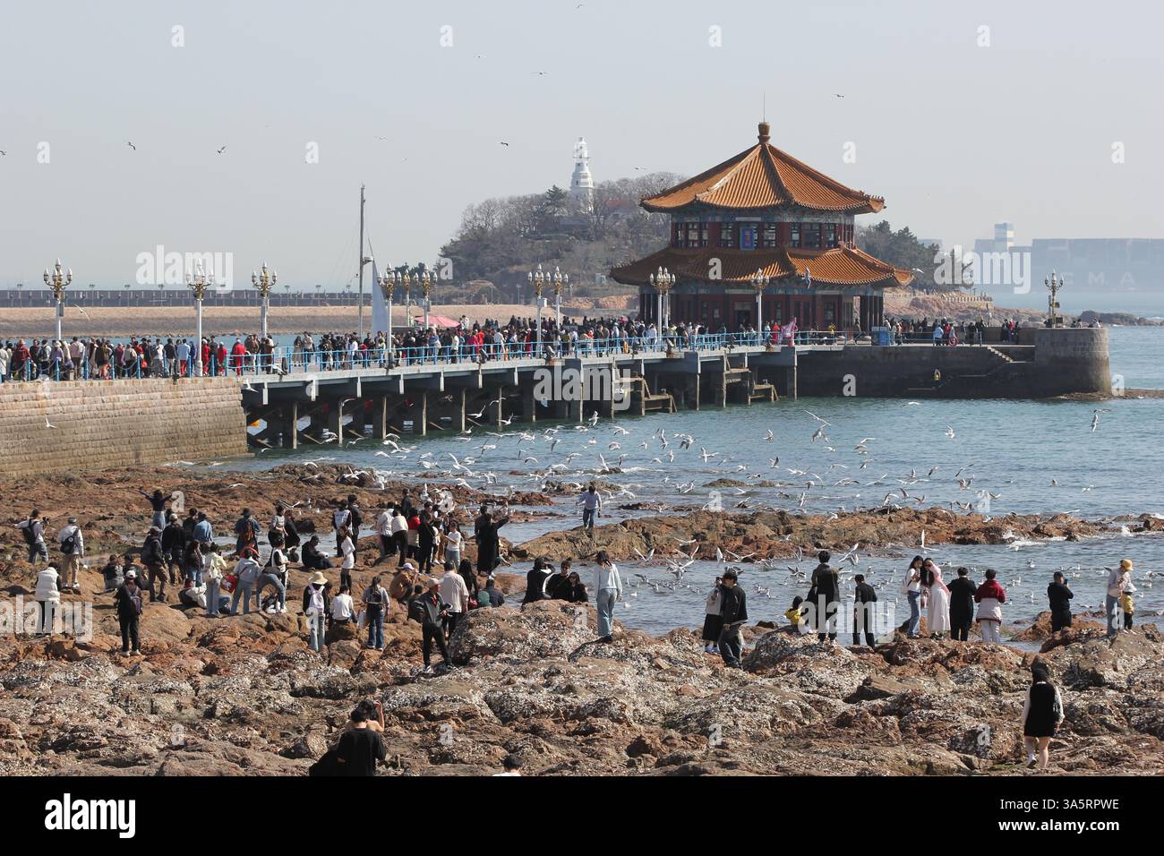 Tourists enjoy spring time at the Zhanqiao Pier scenic area in Qingdao ...