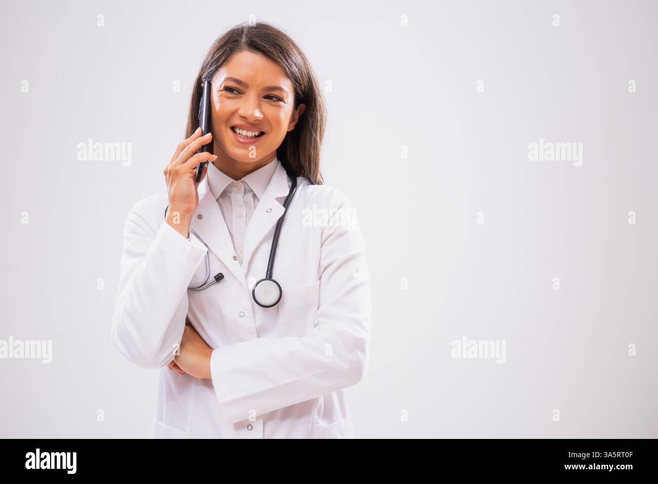Studio shot portrait of cheerful and satisfied female doctor who is ...