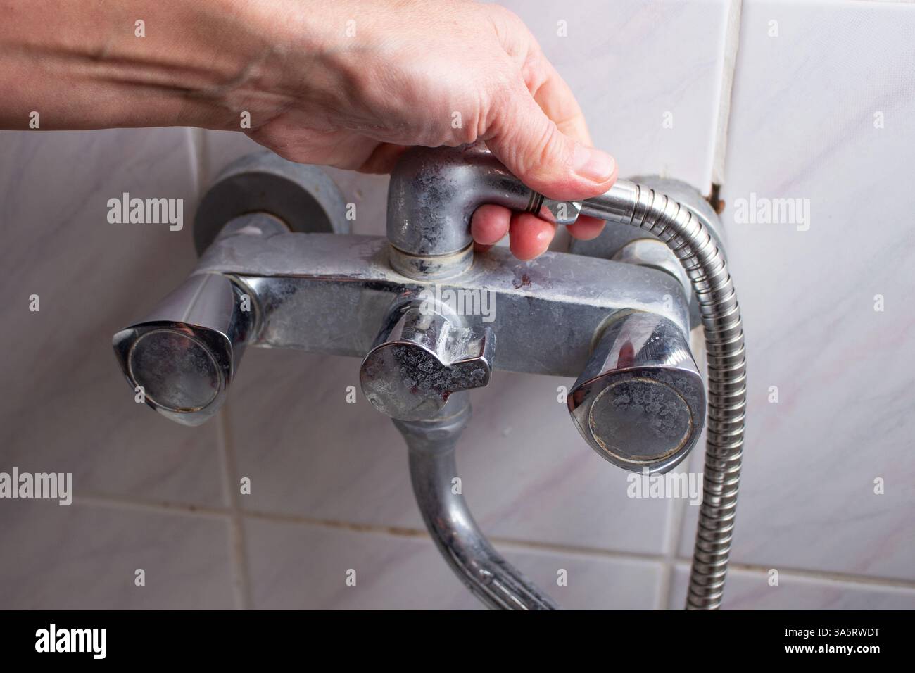Woman changing broken shower hose in bathroom. Female plumber hands ...