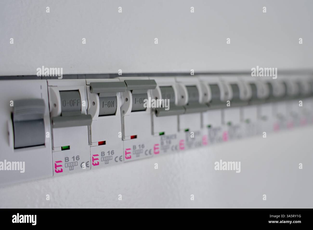 Power distribution board with row of circuit breakers and switches. Electrical panel with fuse ...