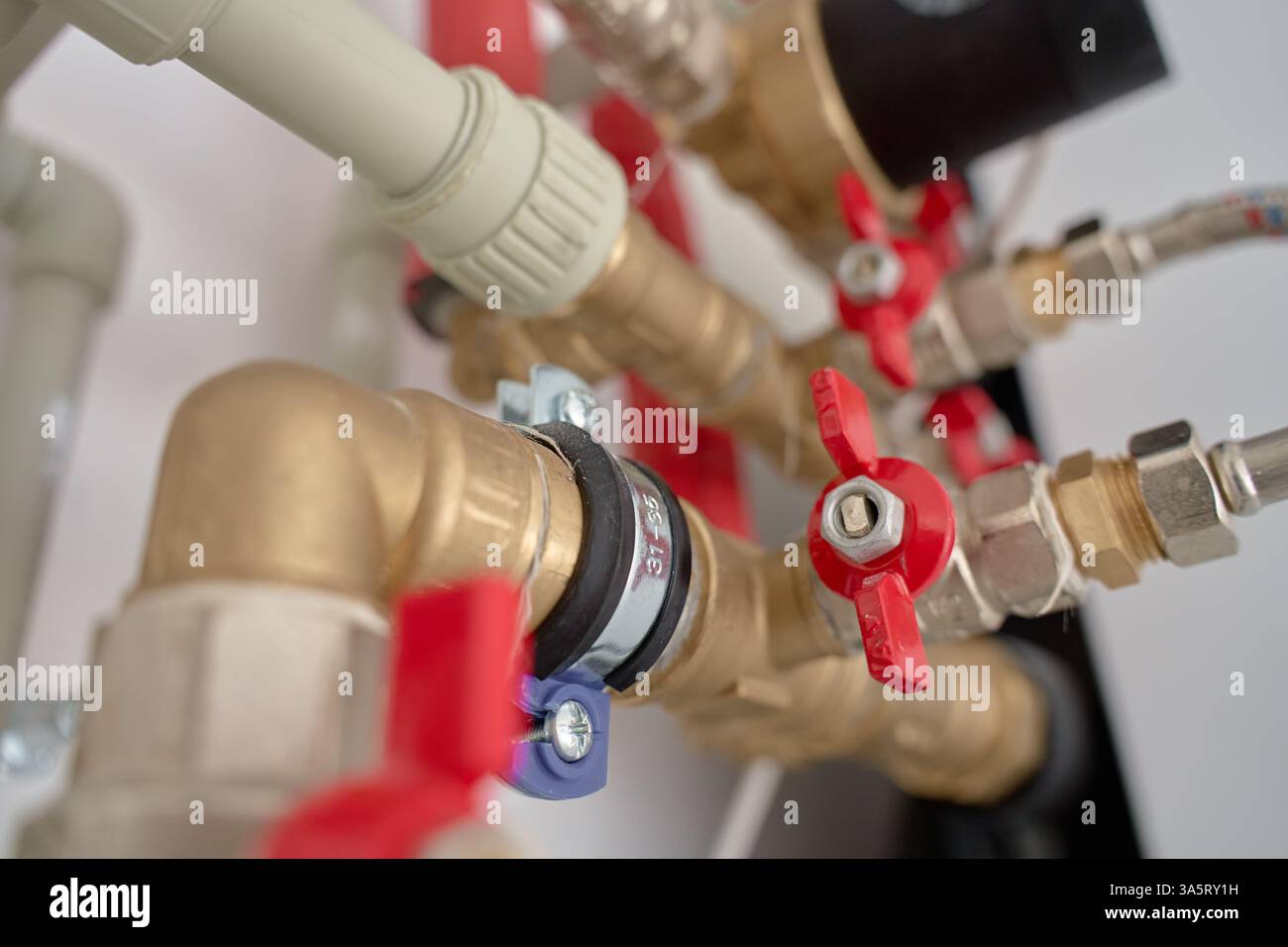 Plumbing system with brass pipes, red valves, and fittings. Heating ...