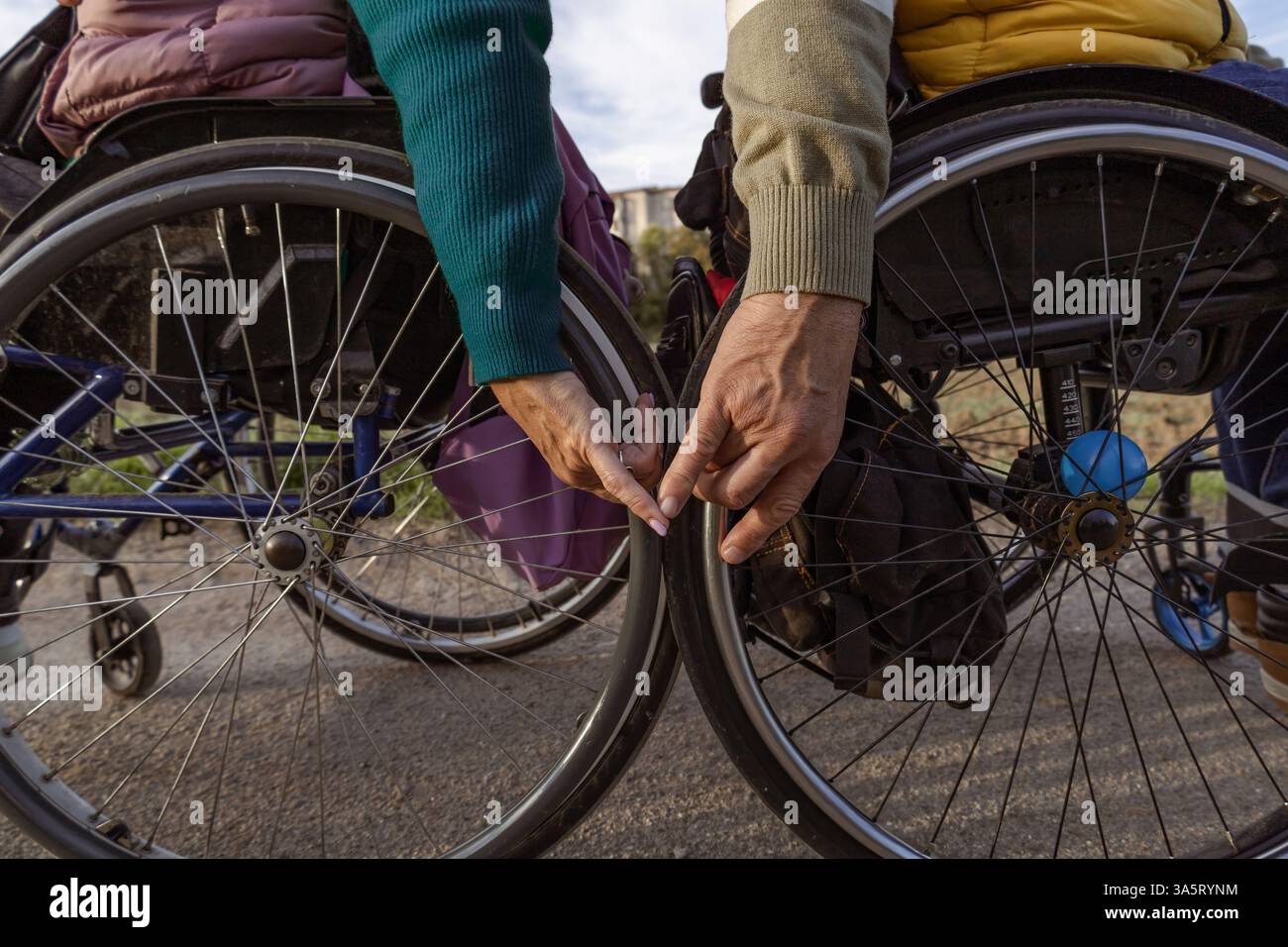Two people with disabilities in wheelchairs are holding hands Stock ...