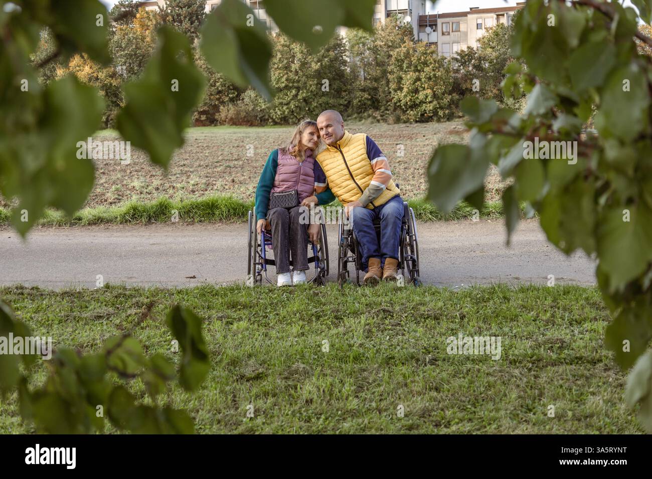 Two people with disabilities in wheelchairs are holding hands Stock ...