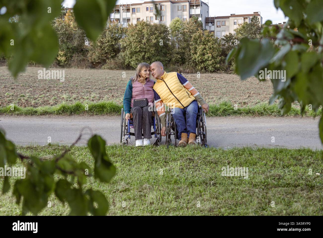 Two people with disabilities in wheelchairs are holding hands Stock ...