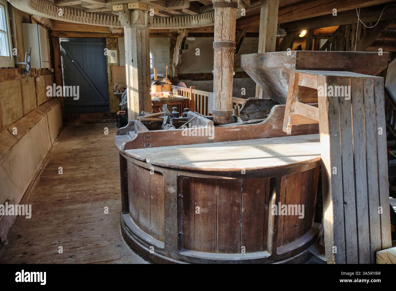 Traditional millstone encased in wood inside a historic mill. Wooden ...