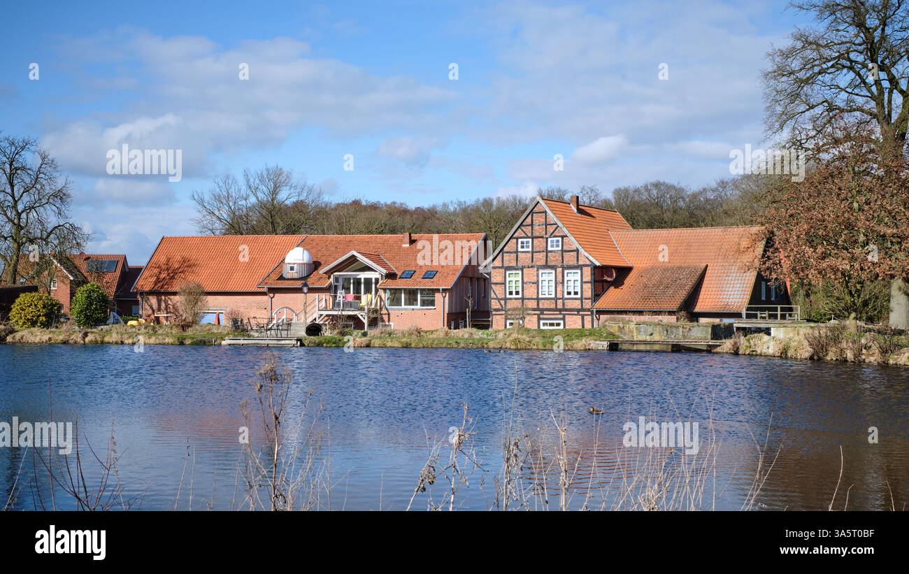 Historic half-timbered German watermill with red roof and reflection in ...