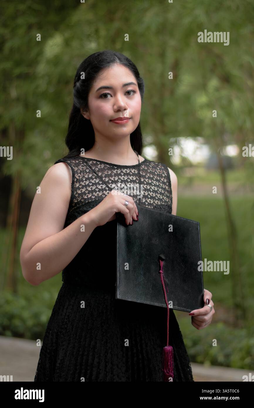Young Woman In Formal Attire Holds Graduation Cap Stock Photo - Alamy
