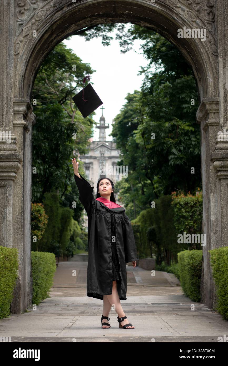 Young Woman Throws Graduation Cap at University Stock Photo - Alamy