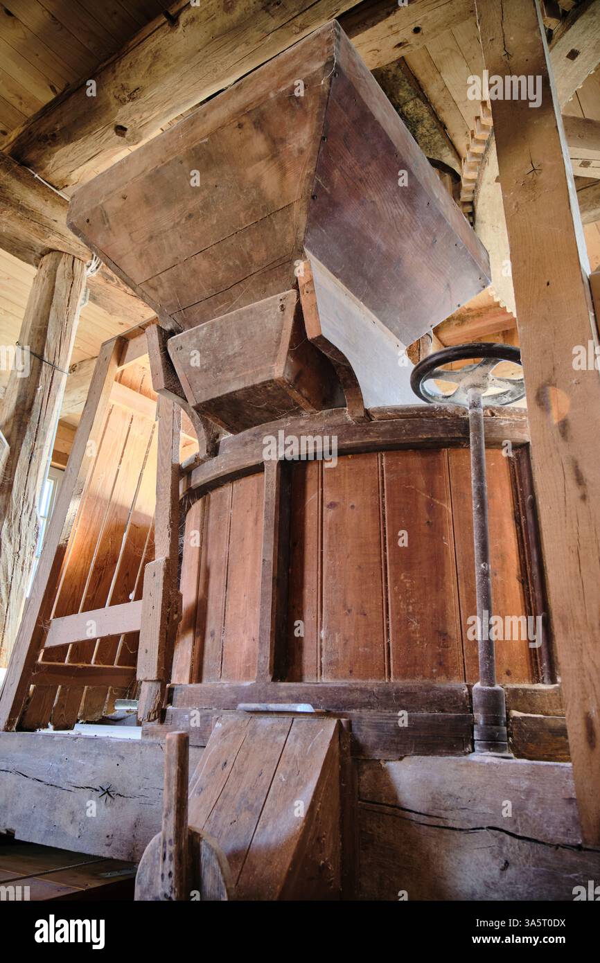Traditional millstone encased in wood inside a historic mill. Wooden ...