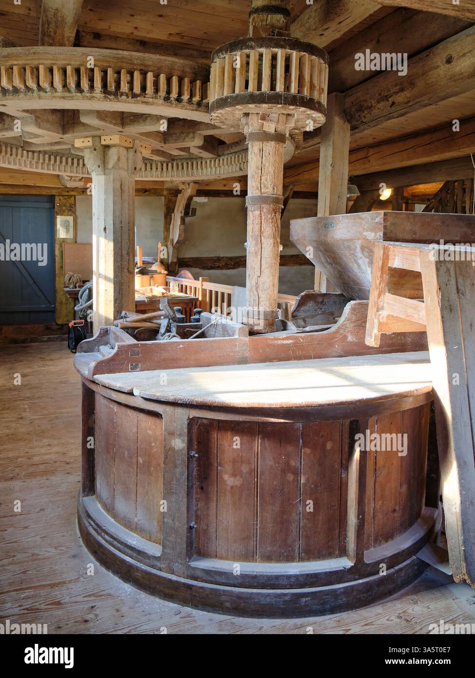 Traditional millstone encased in wood inside a historic mill. Wooden ...