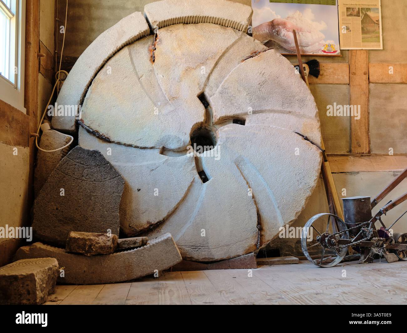 Large segmented peeling stone on display inside a historic mill. The ...