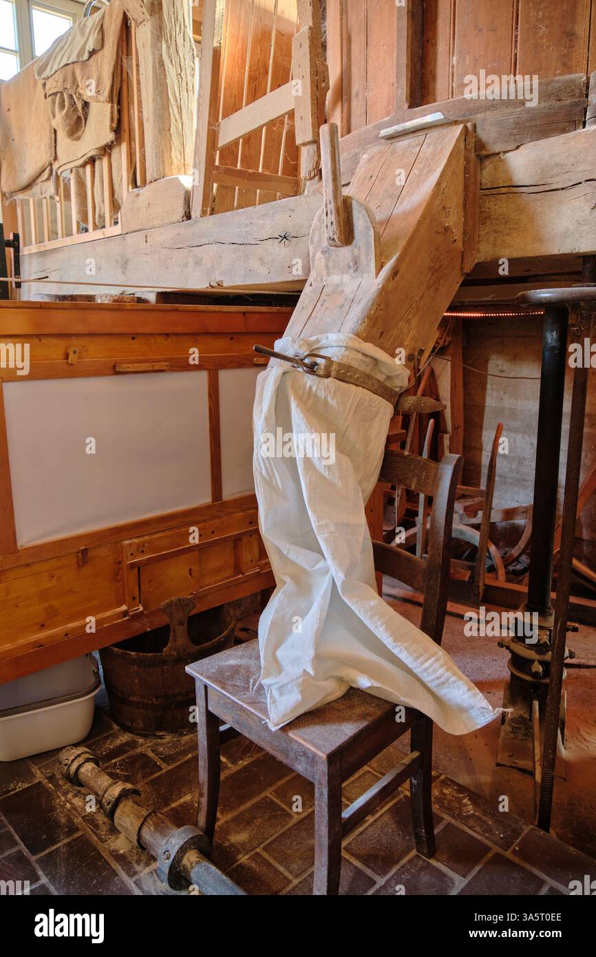 Traditional millstone encased in wood inside a historic mill. Wooden ...