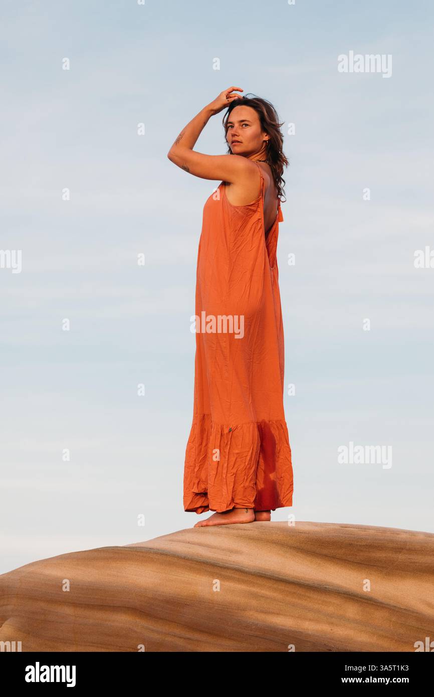 Barefoot woman standing tall on sandstone rock Stock Photo - Alamy