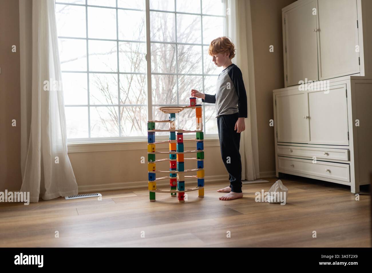 Elementary school boy playing with block marble run at home Stock Photo ...