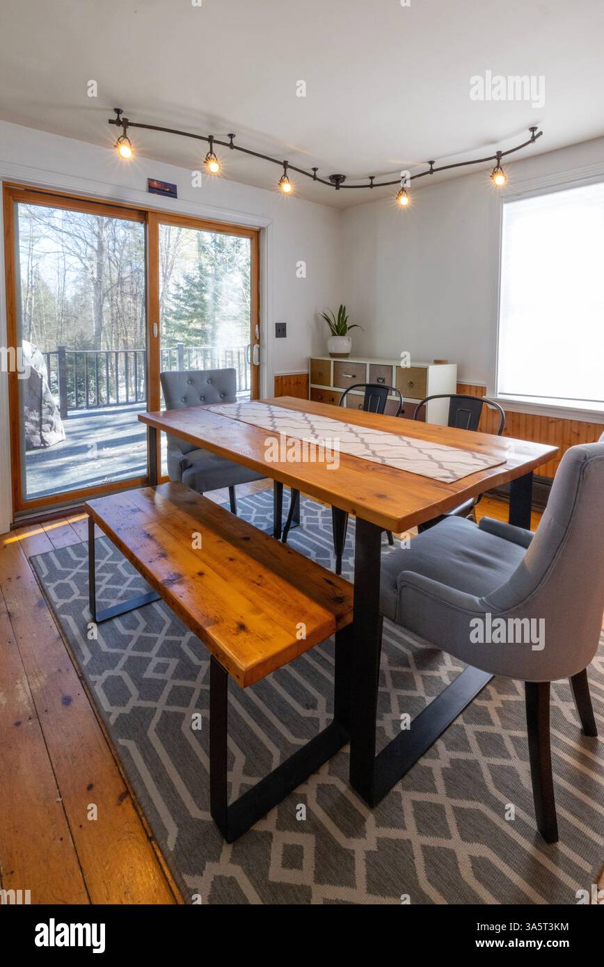 Dining room with overhead lighting, reclaimed wood table and bench ...
