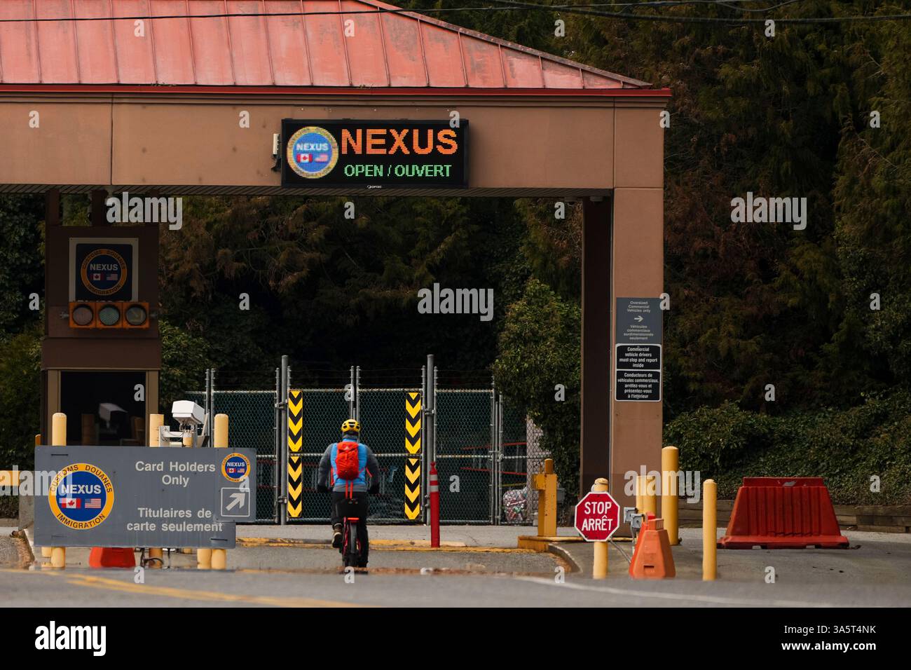 A bicyclist approaches the Nexus lane at the border crossing checkpoint ...