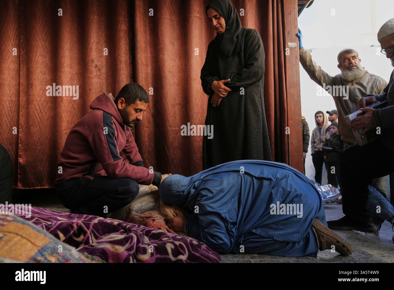 Members of the Al-Kahlout family mourn over the bodies of their relatives killed during an ...
