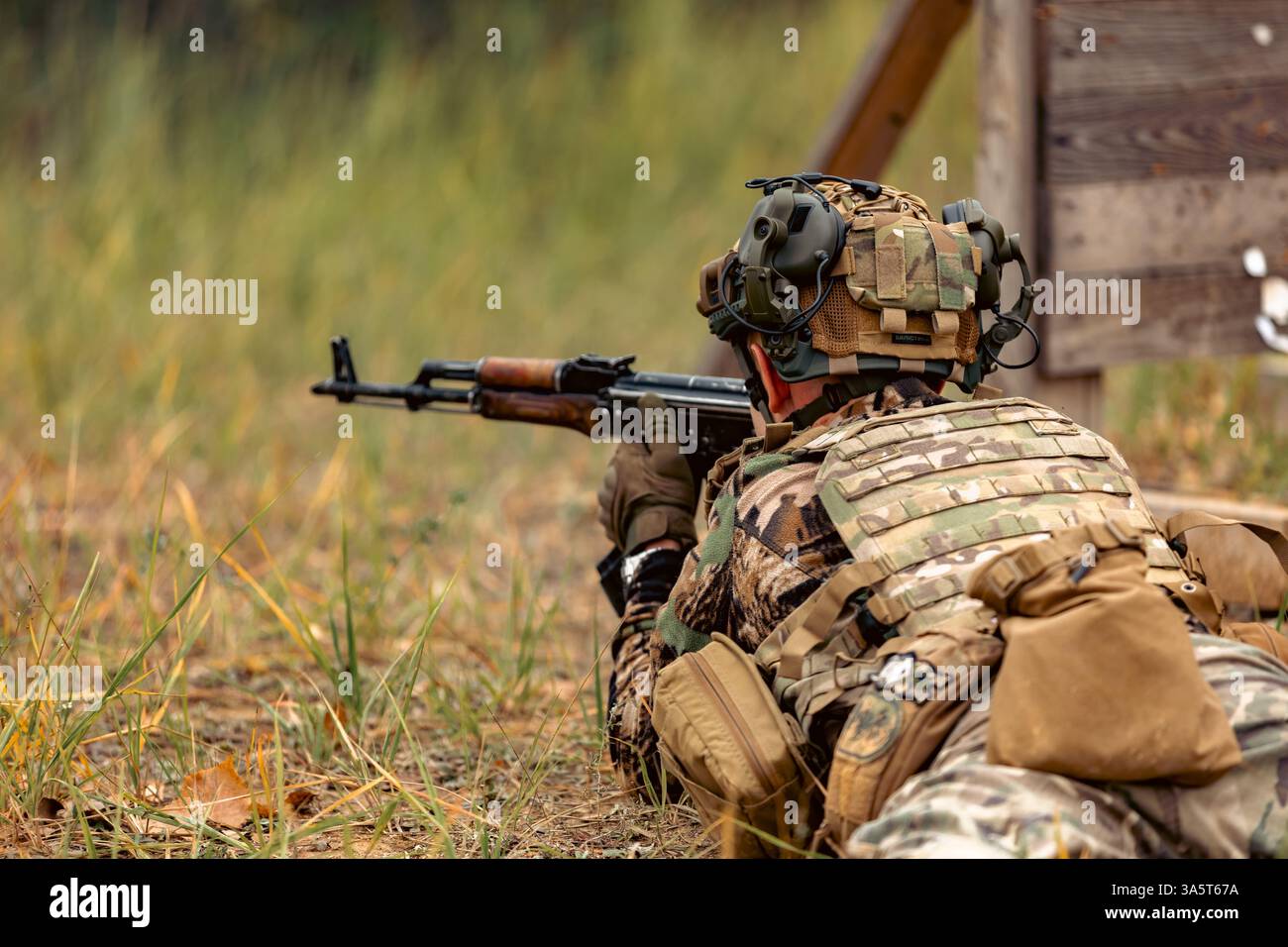 ukrainian military soldier in a helmet and with machine gun shoots ...