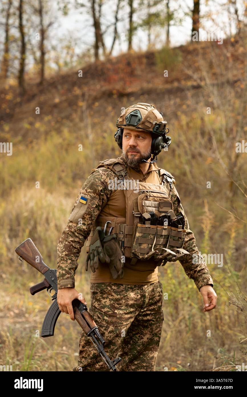 Soldier of Ukraine with assault rifle and flag of Ukraine on military ...
