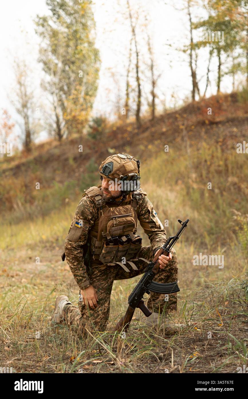 Soldier of Ukraine with assault rifle and flag of Ukraine on military ...