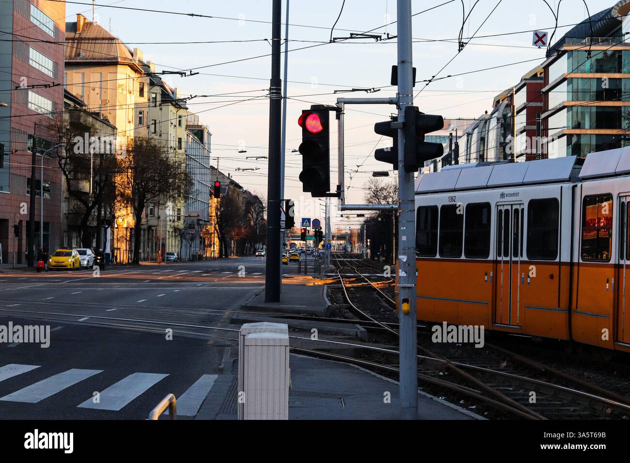 Budapest street scene with a yellow tram at sunset. Tram tracks ...
