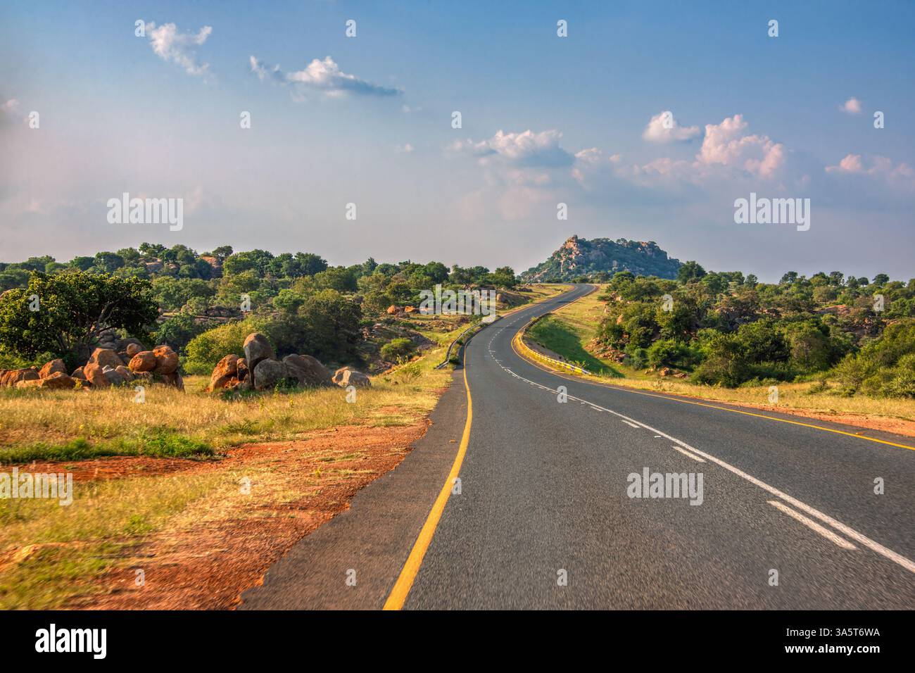 curved road in the nature, south africa landscape with rocky hill and ...