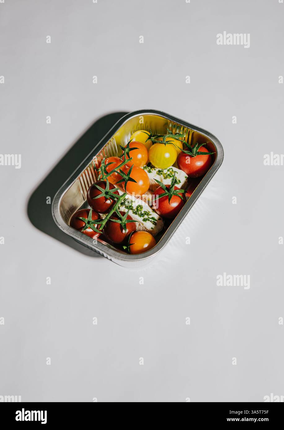 A tray of assorted vegetables including tomatoes and cucumbers. The ...