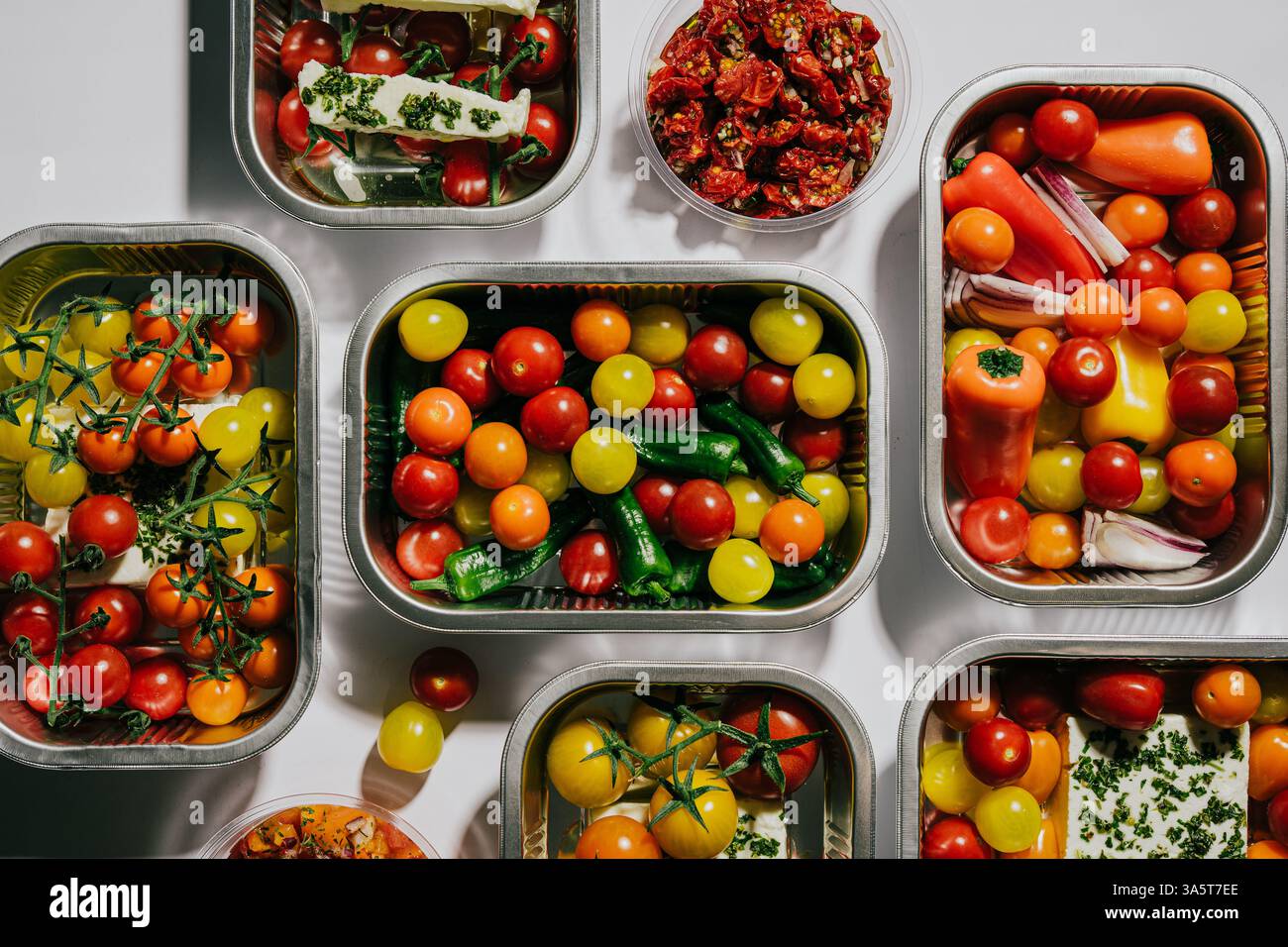 A variety of fruits and vegetables are displayed in aluminum trays. The ...