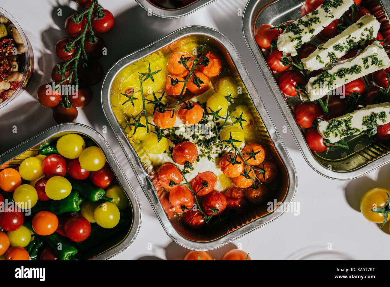A variety of fruits and vegetables are displayed in aluminum trays. The ...