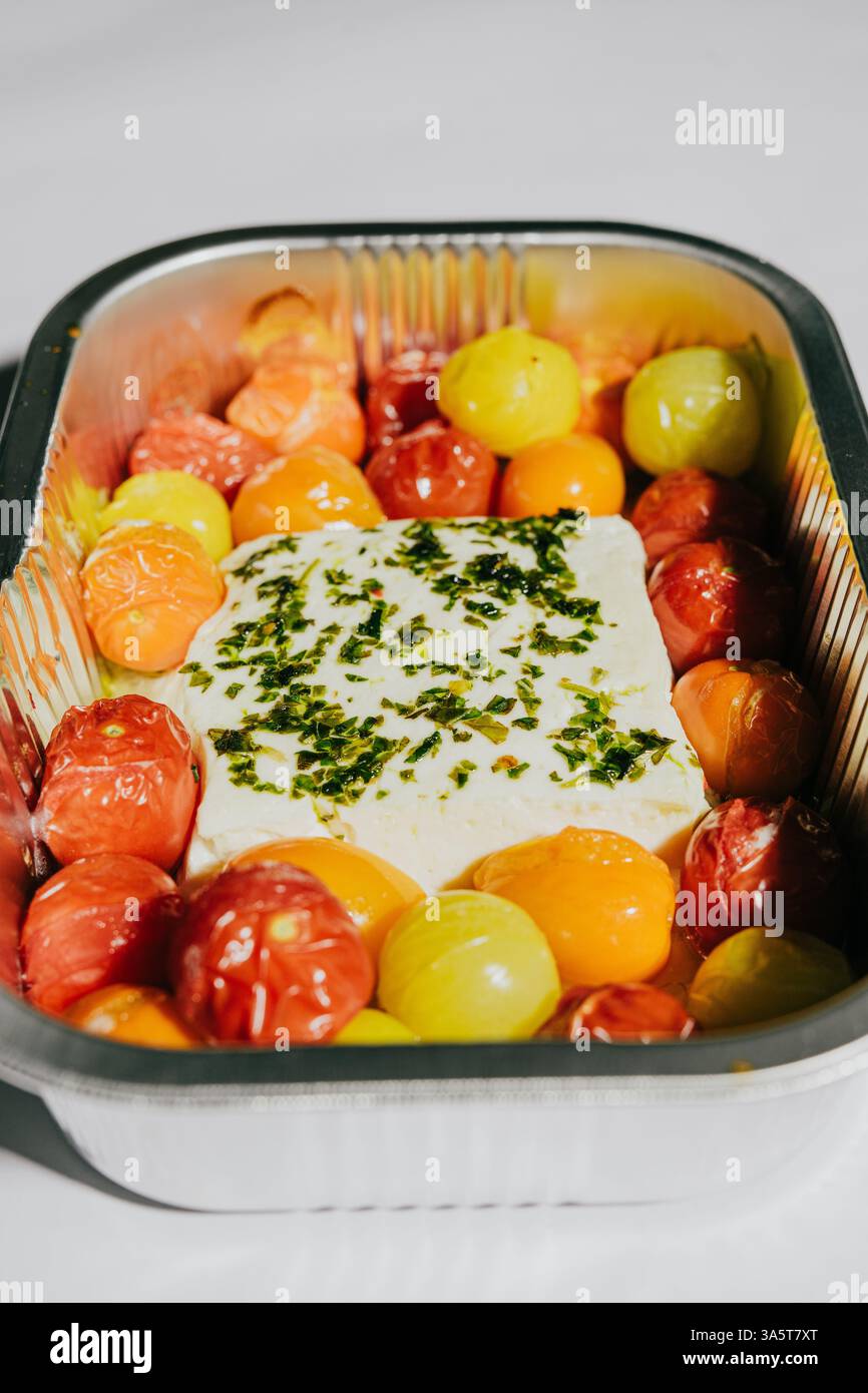 A tray of food with tomatoes and cheese. The tray is silver and has a ...